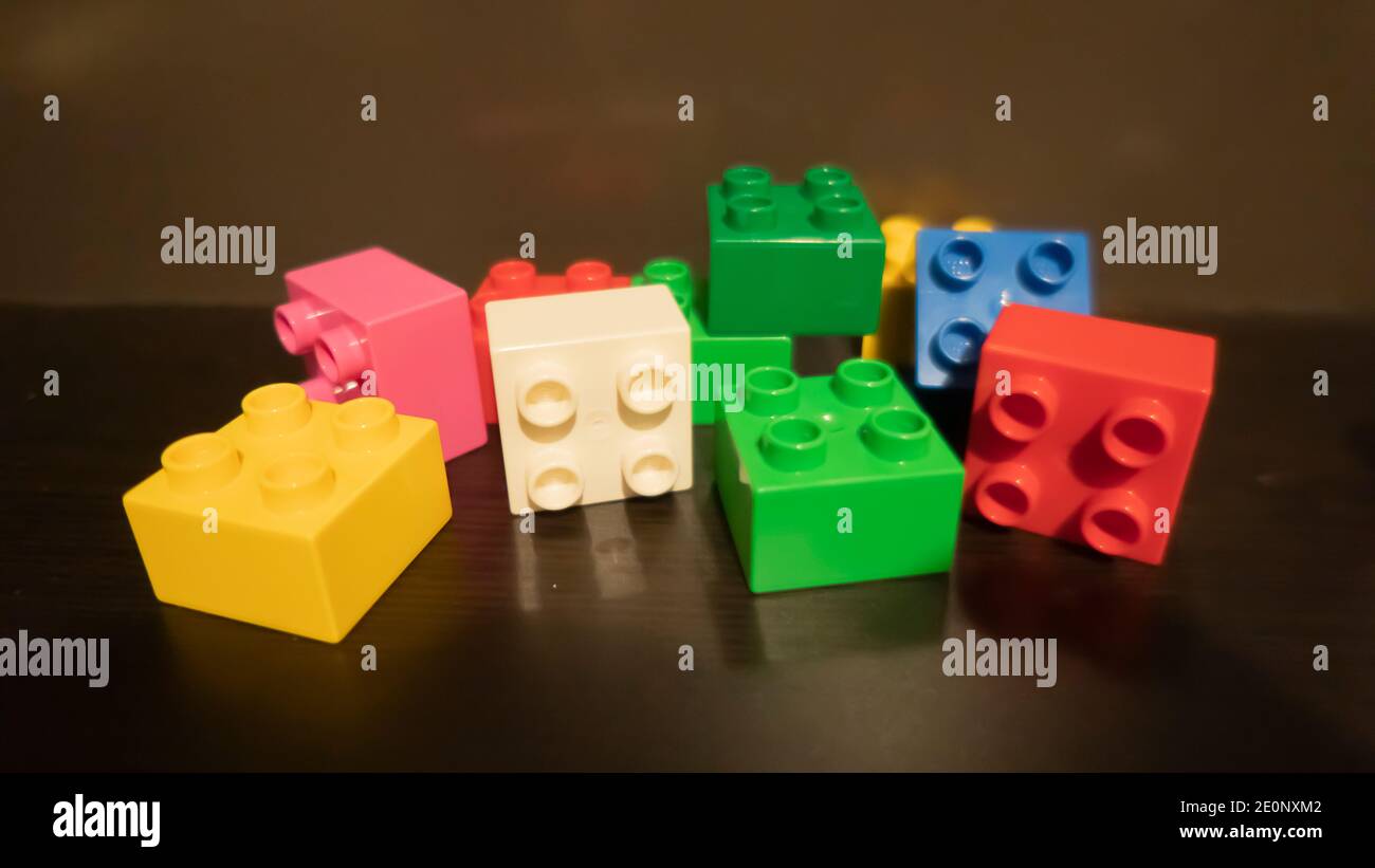 Toy colorful plastic blocks isolated on dark background Stock Photo - Alamy