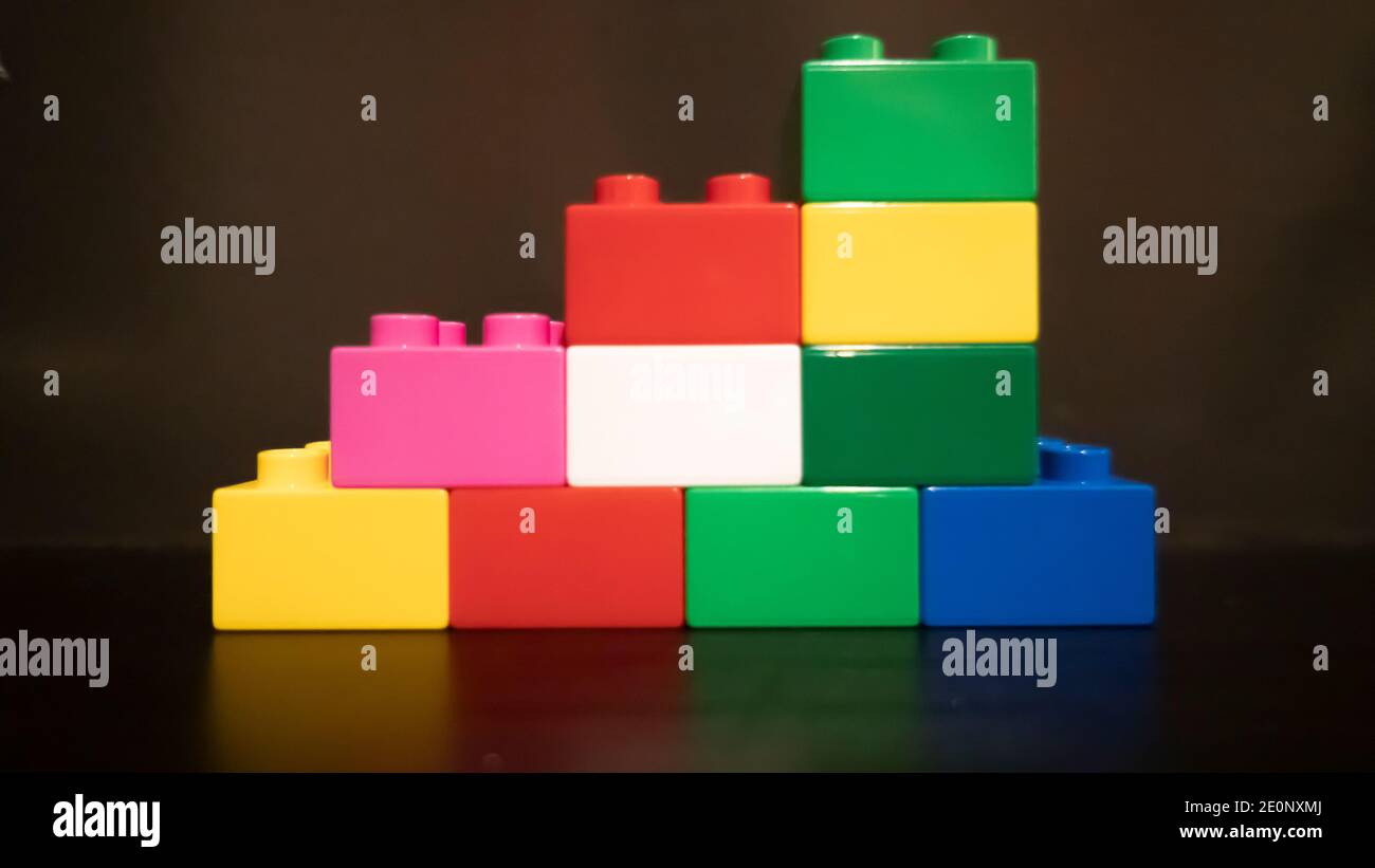 Toy colorful plastic blocks isolated on dark background Stock Photo - Alamy