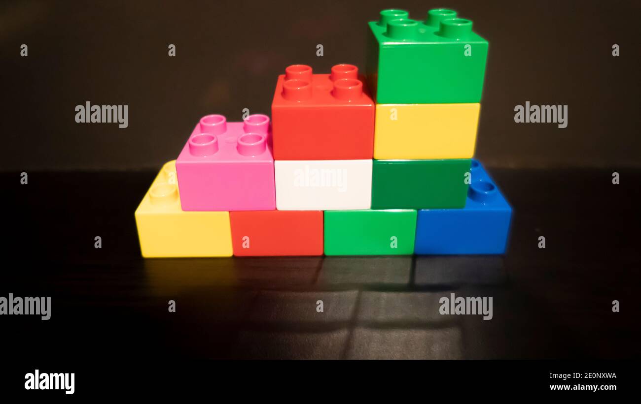 Toy colorful plastic blocks isolated on dark background Stock Photo - Alamy