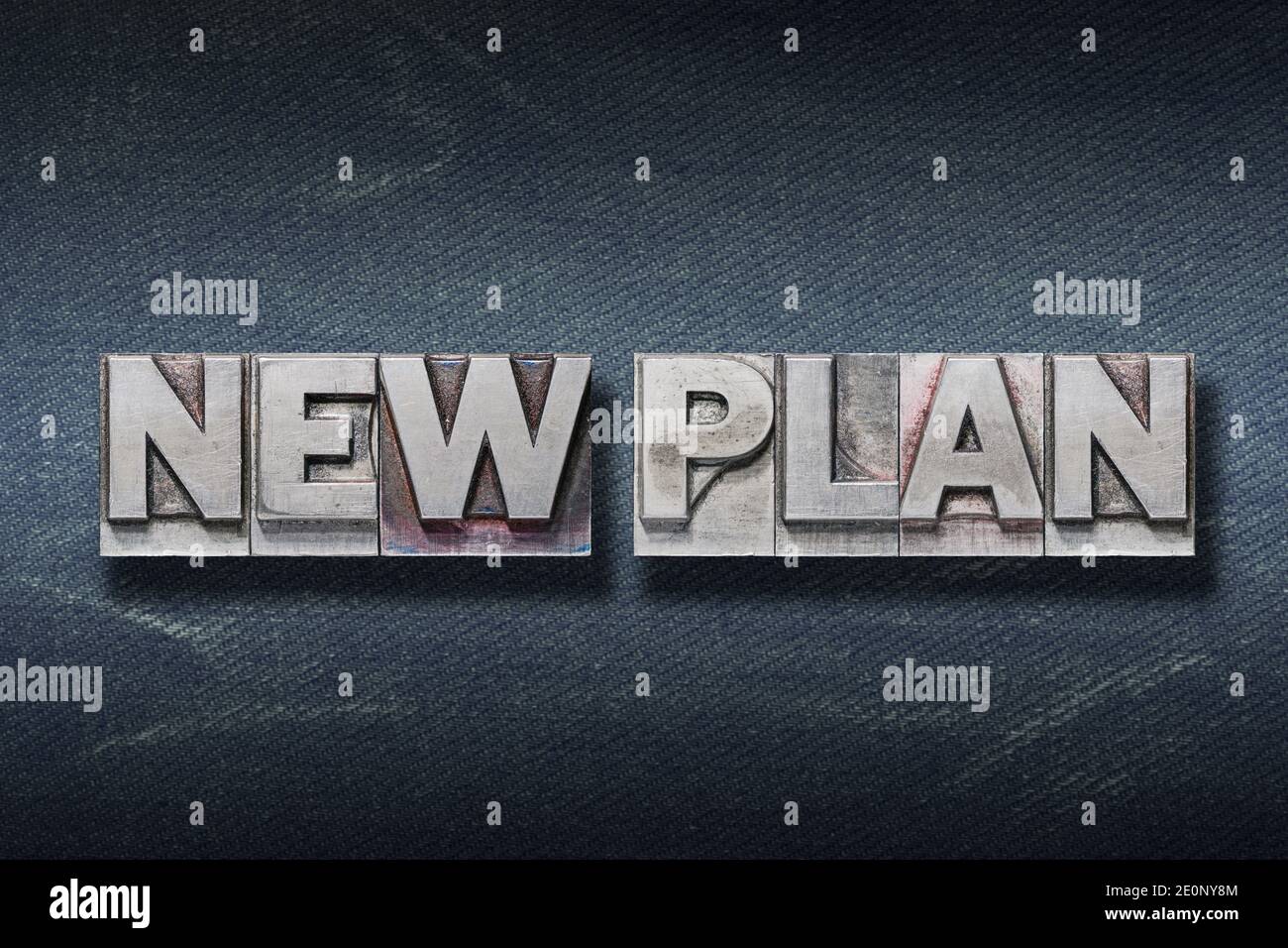 new plan phrase made from metallic letterpress on dark jeans background ...