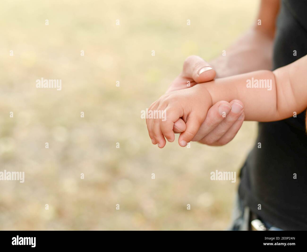 little baby hand with father's hand on light background with copy space ...