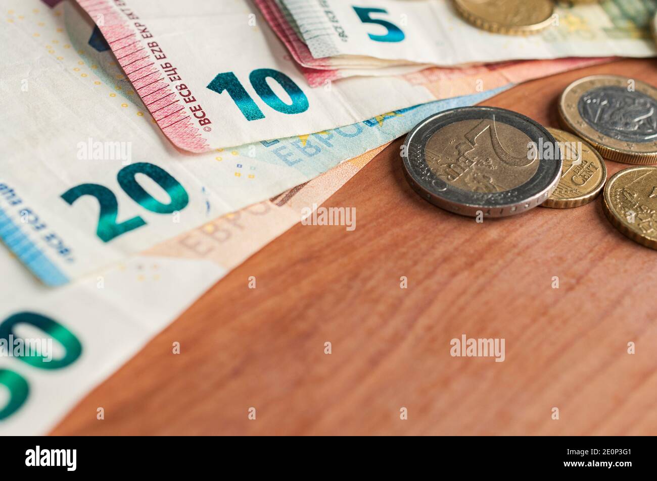 Fan of euro banknotes and some coins on a wooden table Stock Photo - Alamy