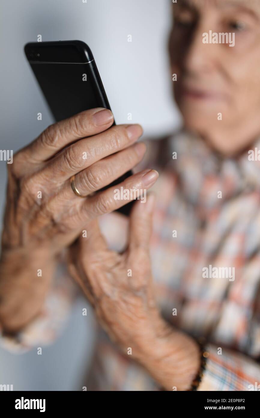 Hands of an elderly person using a smartphone. Technology concept Stock ...