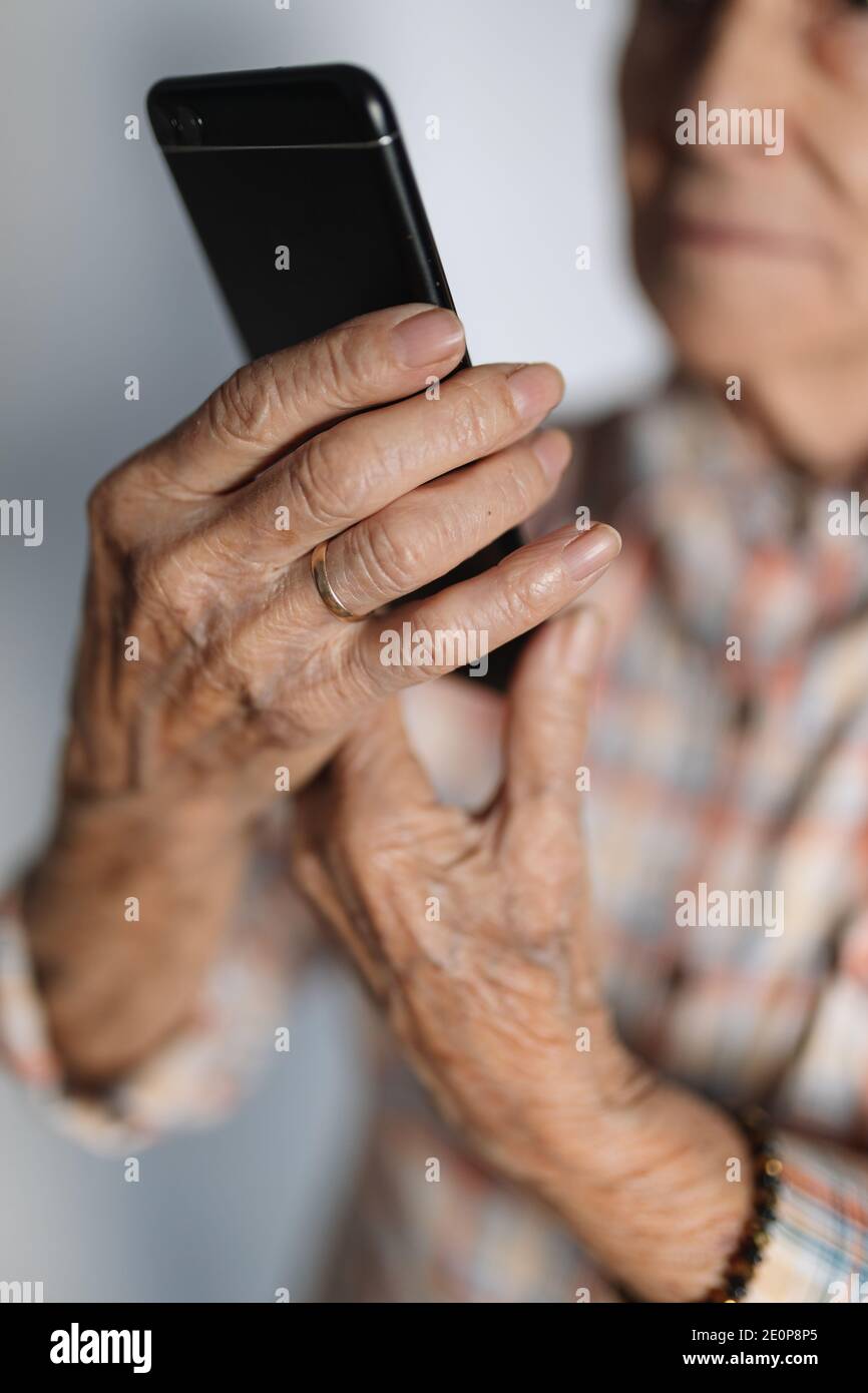Hands of an elderly person using a smartphone. Technology concept Stock ...