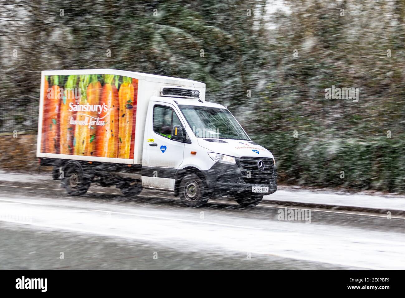 A Sainsbury delivery van makes its way through falling snow, UK Stock ...