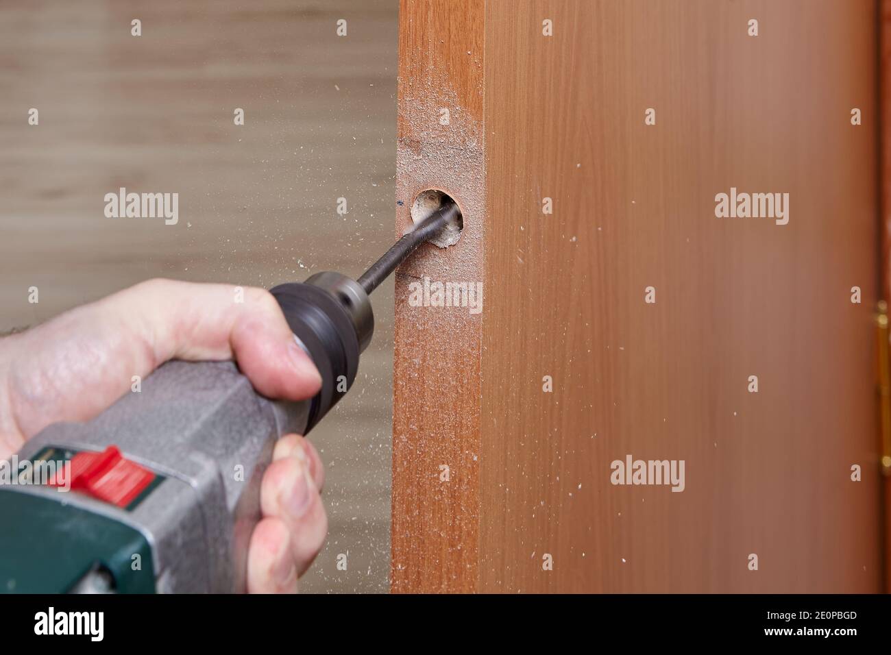 The carpenter uses a flat bit shank drill for wood to drilling a handle ...