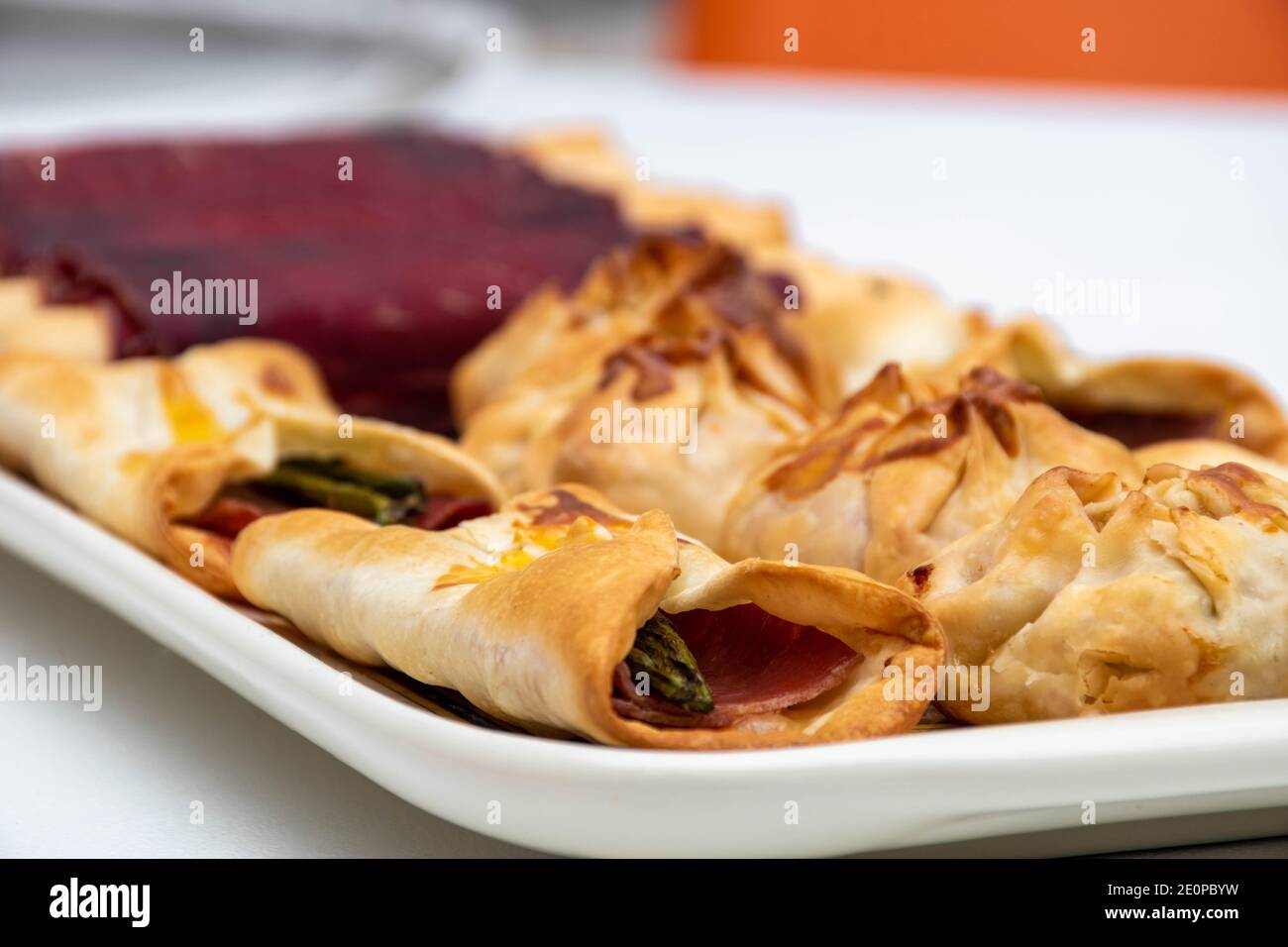 Horizontal macro view of canapés and sachets with vegetables and ham ...