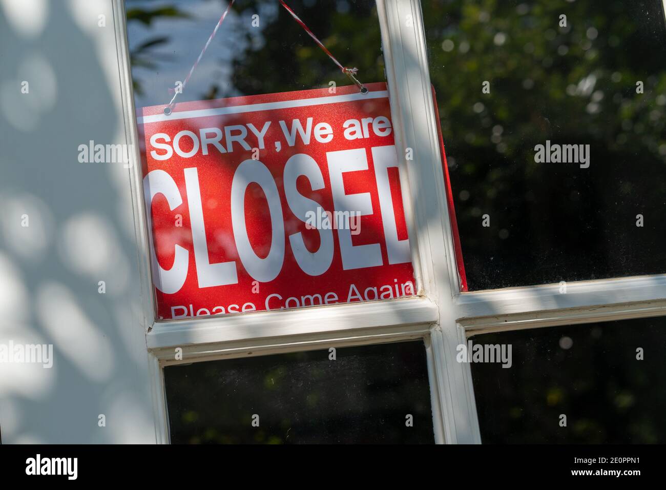 Red closed sign hanging on the white entrance door of a business office ...
