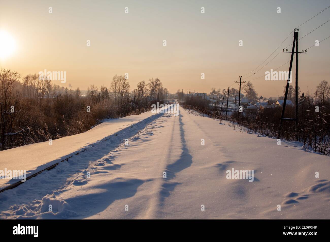 A snow-covered railway and a path trodden by people on it in winter ...
