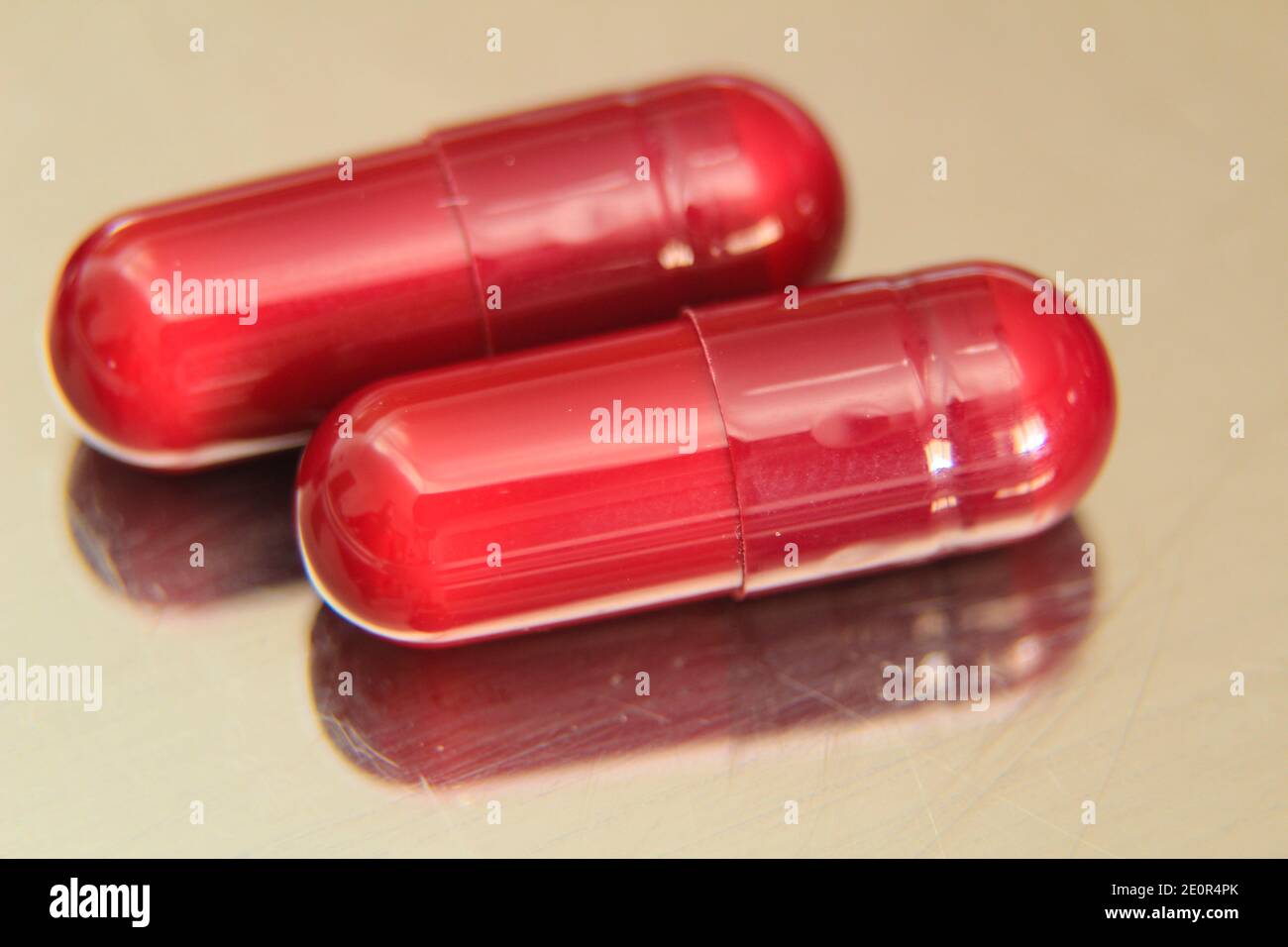 Red capsules on metallic surface background Stock Photo - Alamy