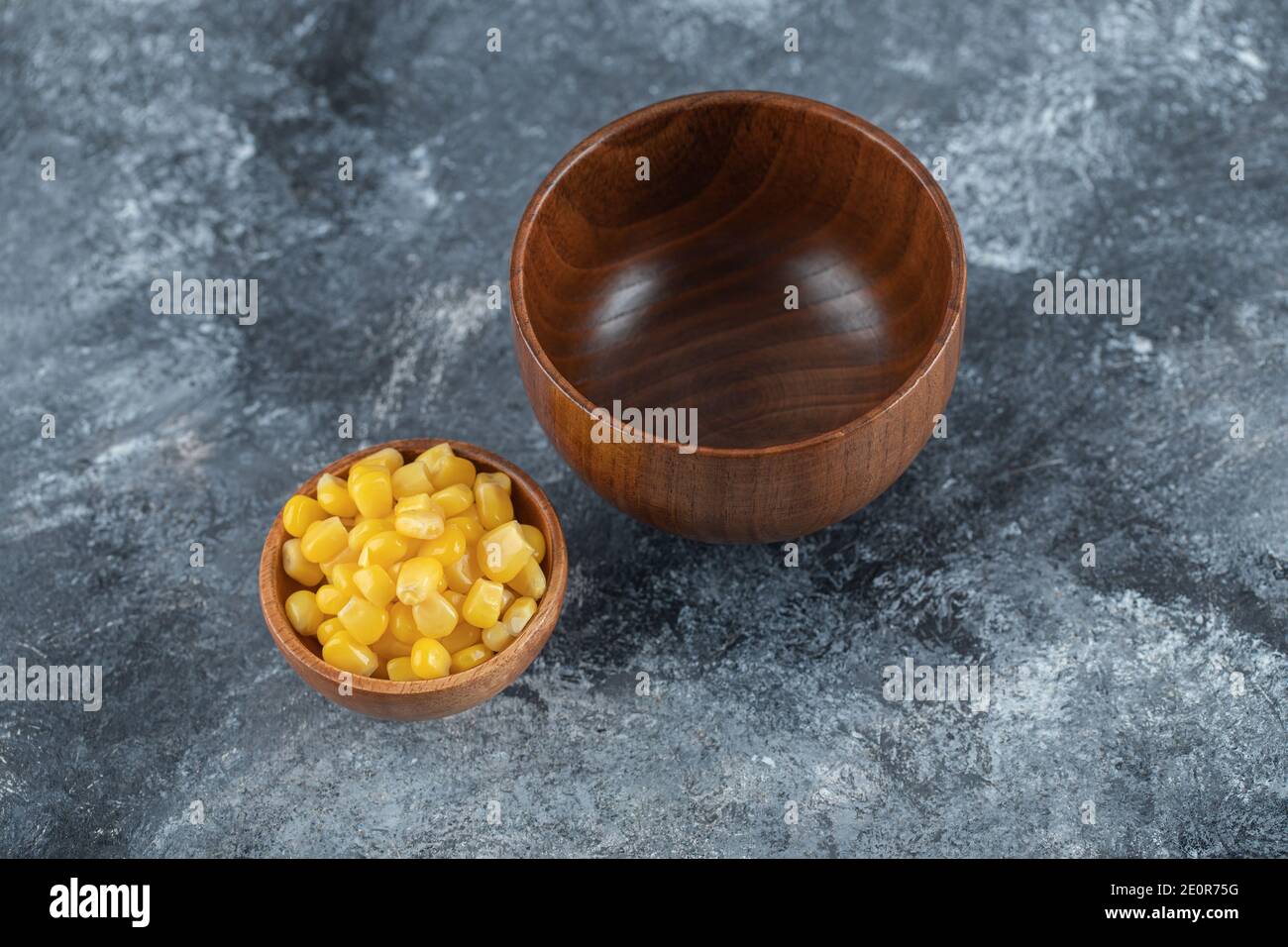 An empty wooden bowl with small bowl of popcorn seeds Stock Photo - Alamy