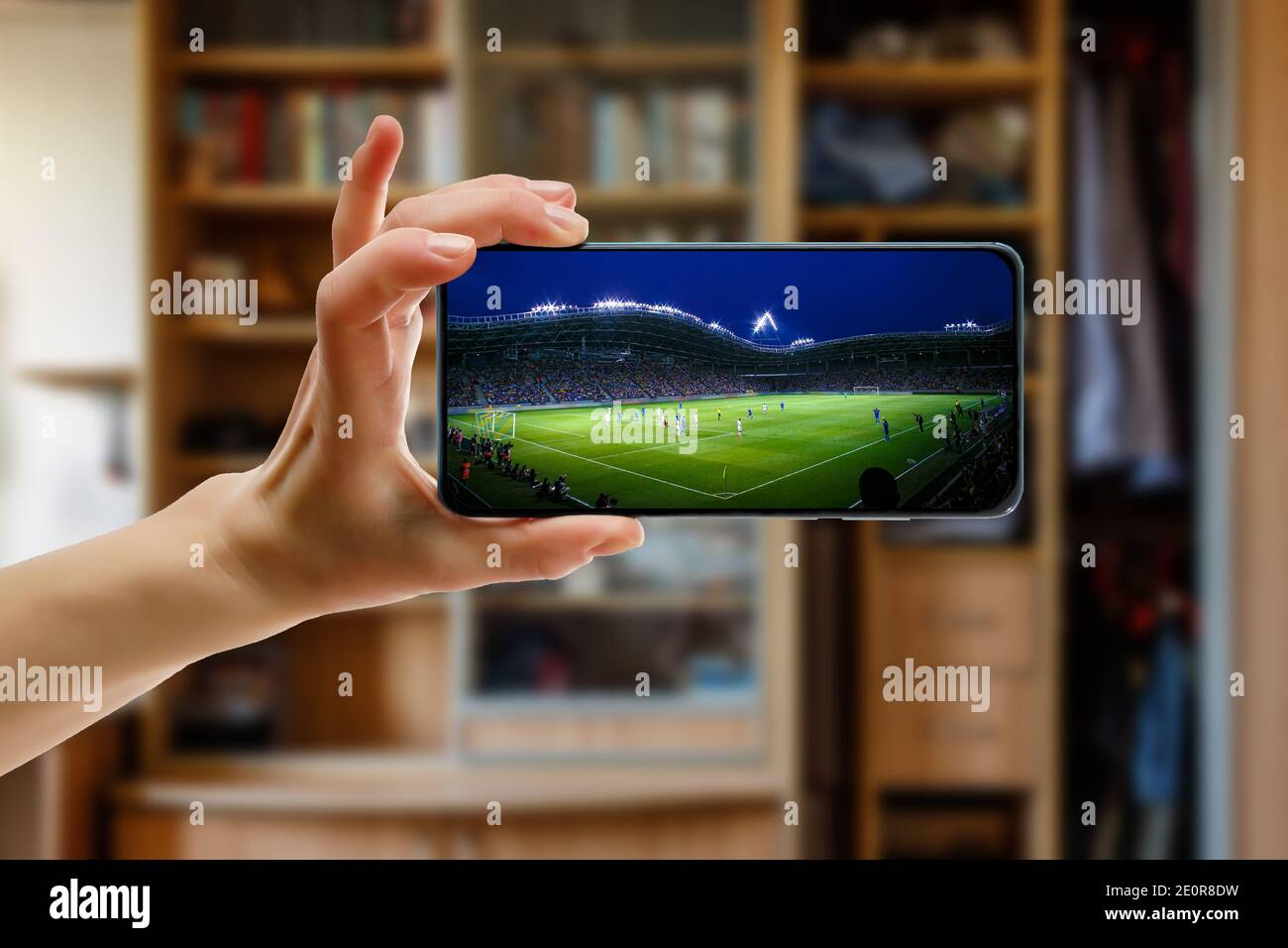 Watching football game at home via smartphone. Broadcasting soccer from ...