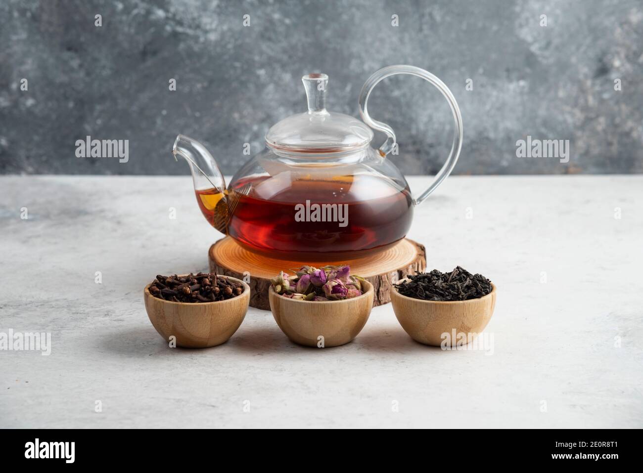 A glass teapot with wooden bowls of loose teas Stock Photo - Alamy