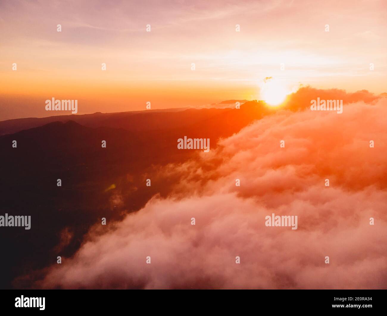 Aerial view over clouds with warm sunrise Stock Photo - Alamy