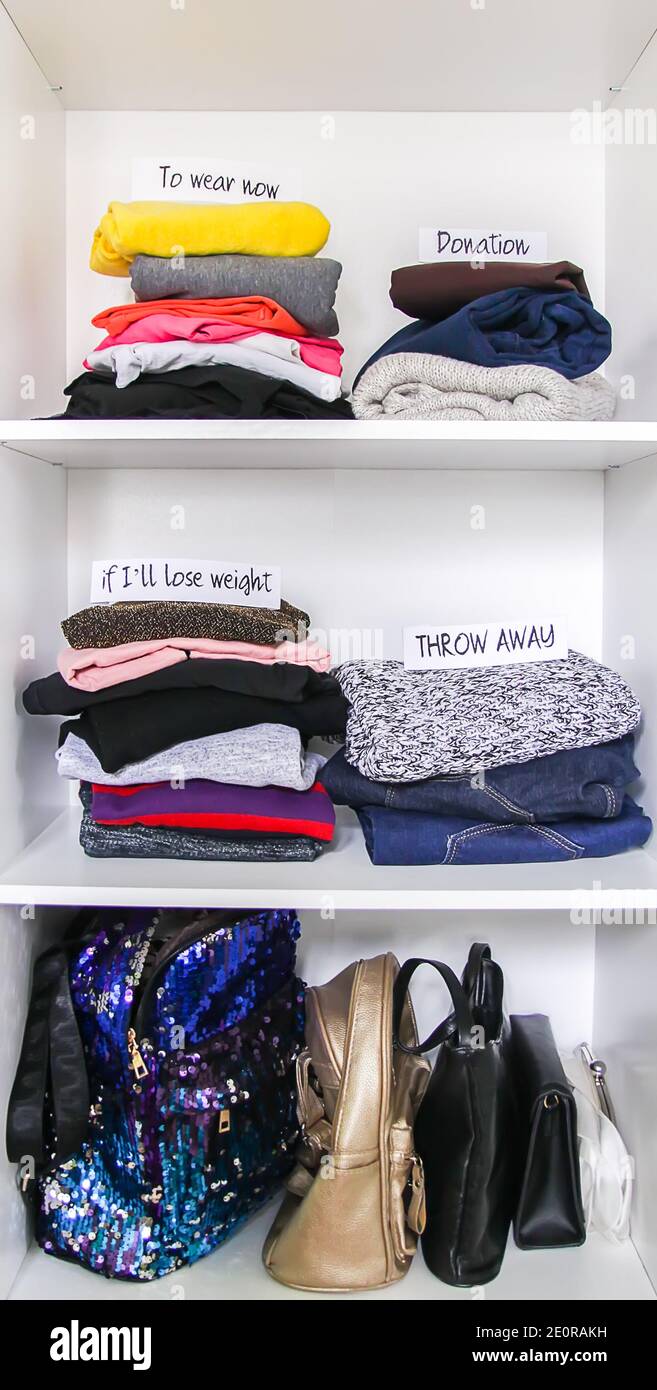 Clothes sorting in home wardrobe for wearing and discard on white shelf ...