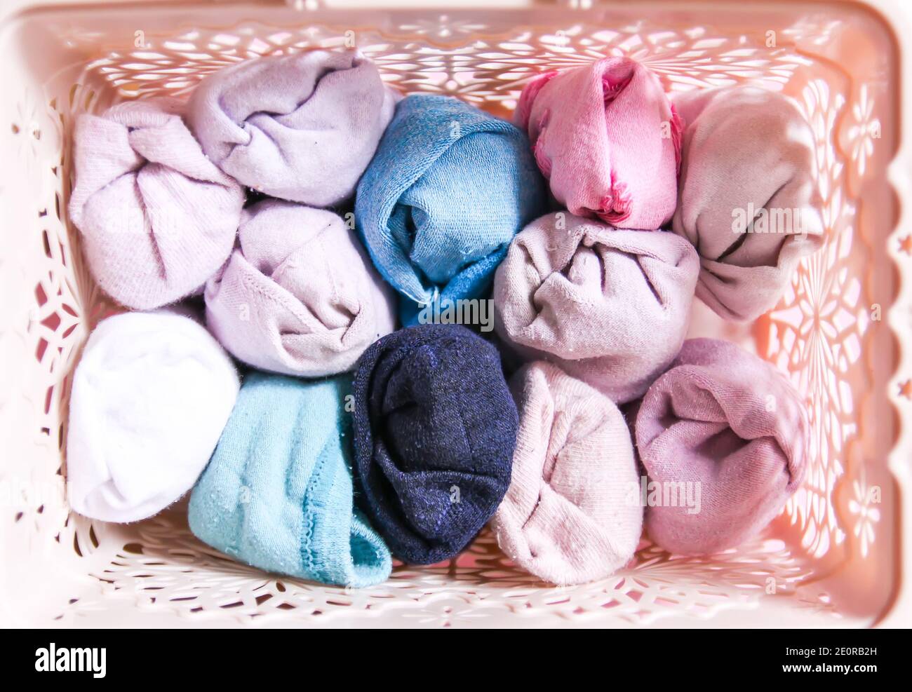 Colorful clothes vertical storage in home wardrobe. Socks in a plastic ...