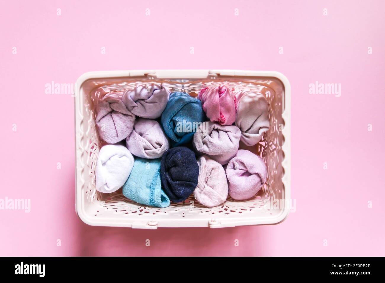 Colorful clothes vertical storage in home wardrobe. Socks in a plastic ...