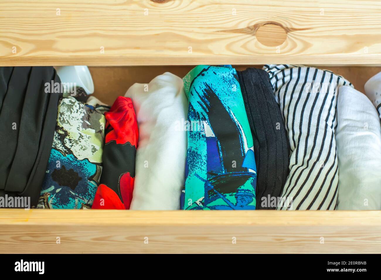 Open light wooden dresser drawer with colorful clothes Stock Photo - Alamy