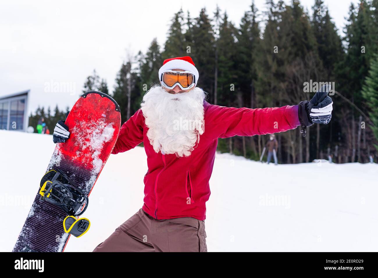 Serious santa claus in ski mask standing with snowboard Stock Photo - Alamy