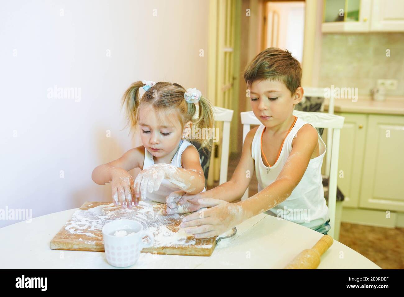Happy family funny kids are preparing the dough, playing with flour in ...