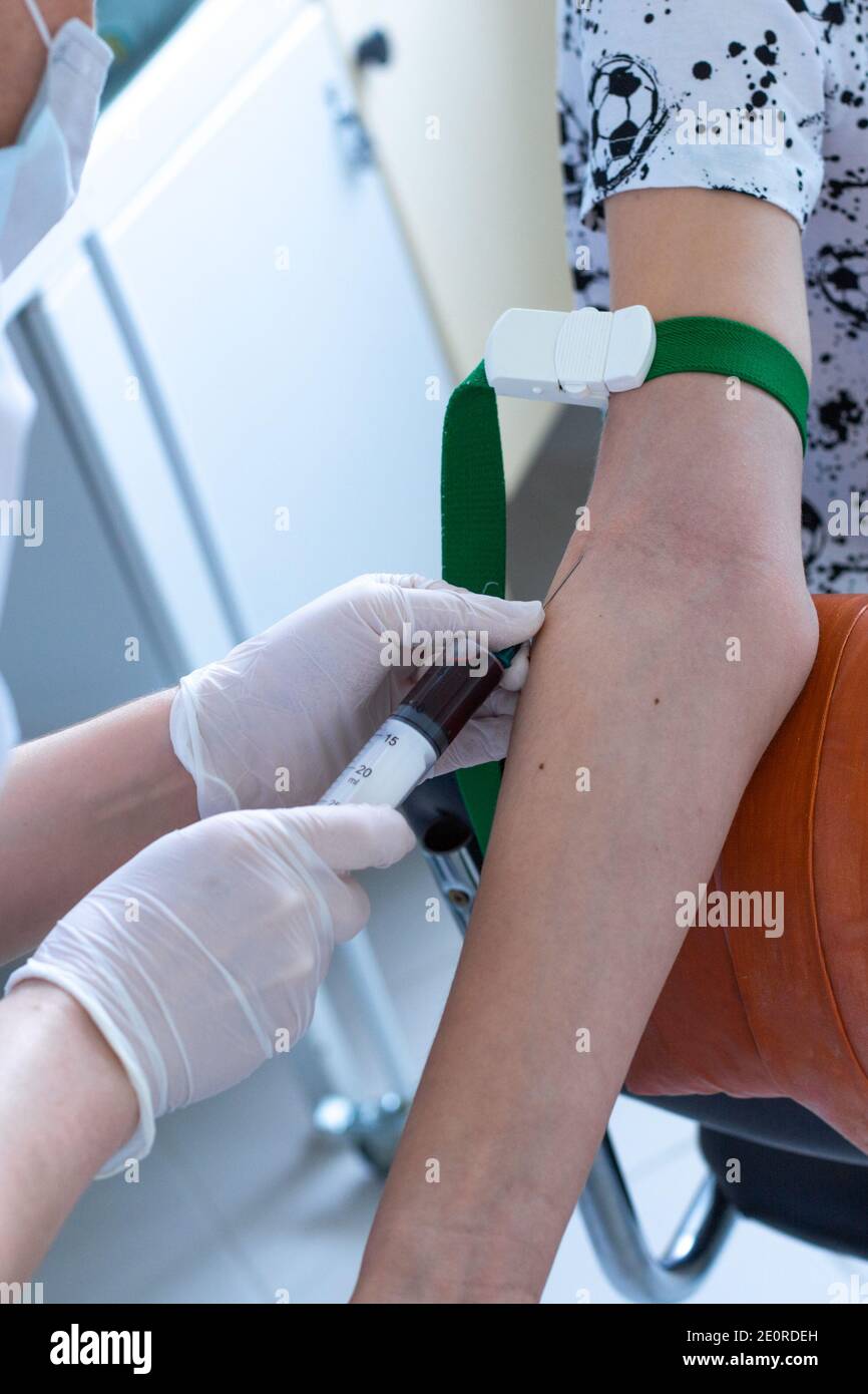 a nurse with a syringe takes venous blood for analysis in the treatment ...