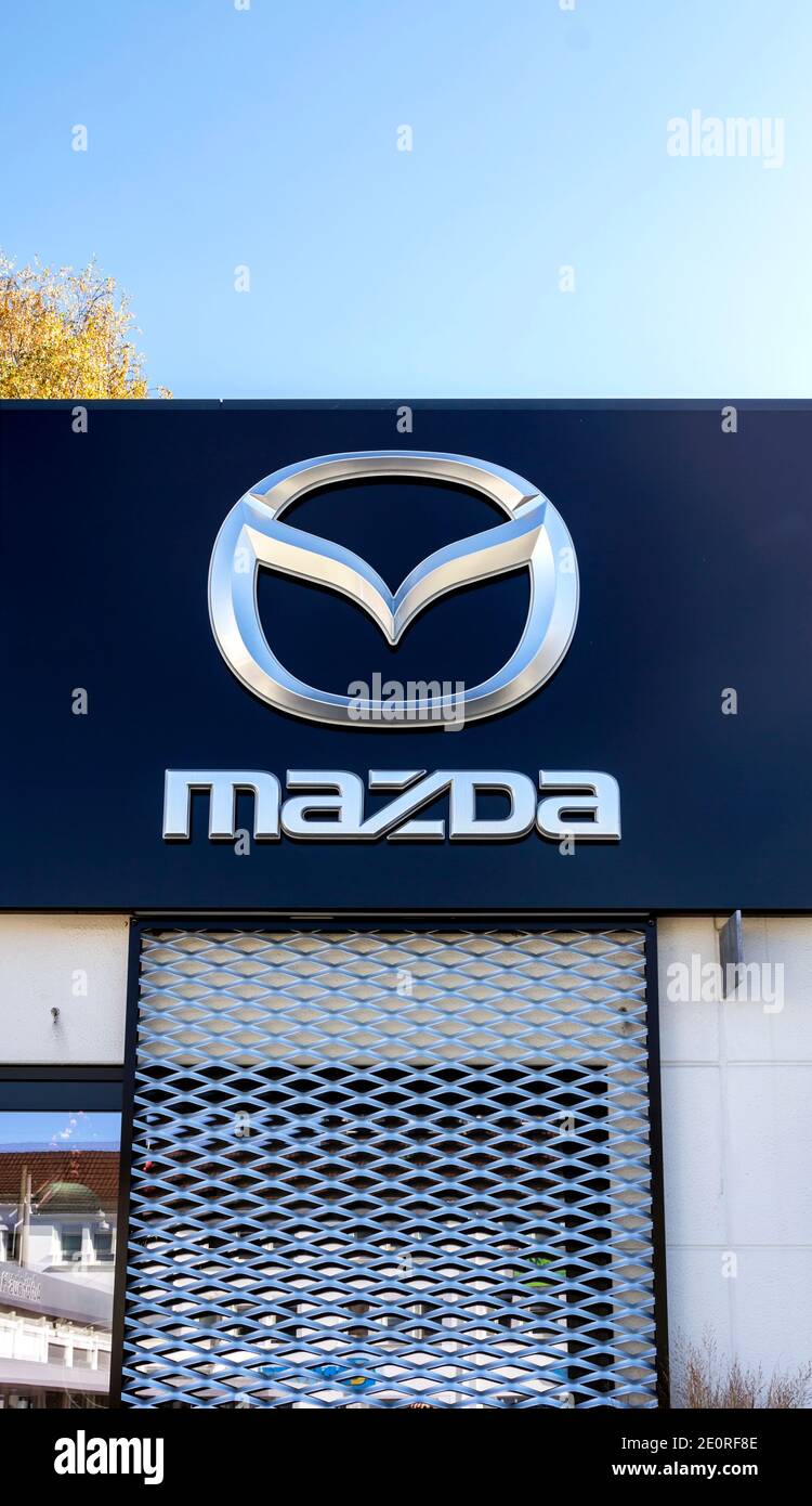Nuremberg, GERMANY: Mazda dealership sign against blue sky. Mazda is a ...