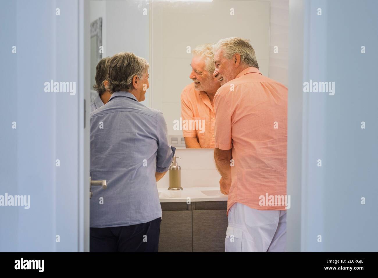 Real life for senior mature couple at home washing hand in the bathroom ...