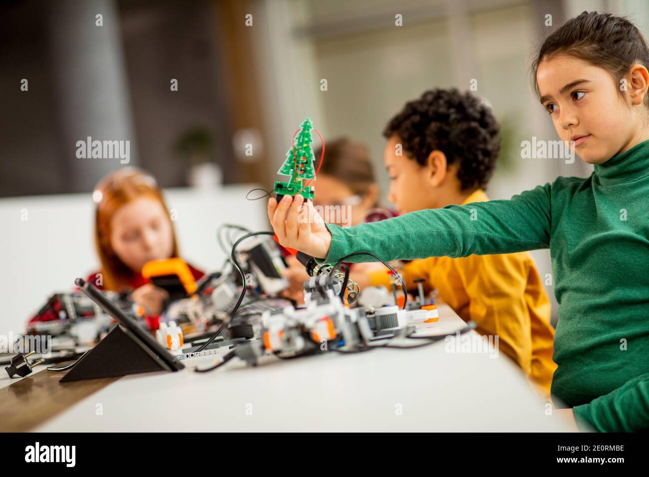 Group of happy kids programming electric toys and robots at robotics ...