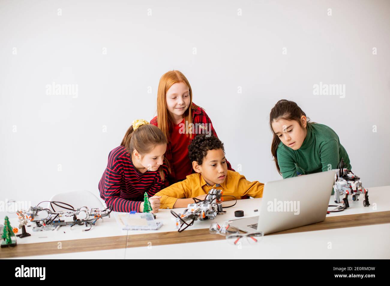 Group of happy kids programming electric toys and robots at robotics ...