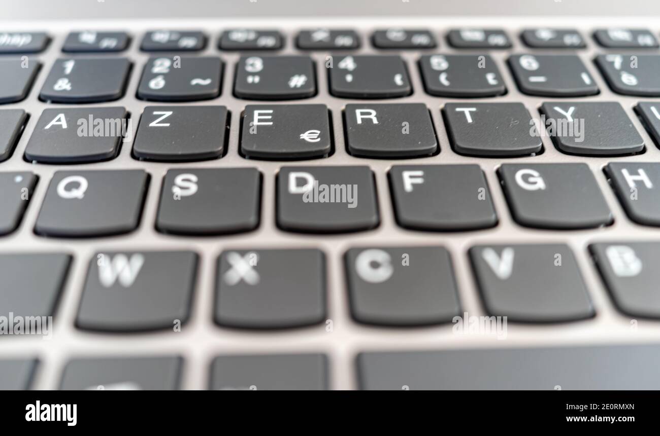 close-up of a computer keyboard with dark and flat keys on silver ...