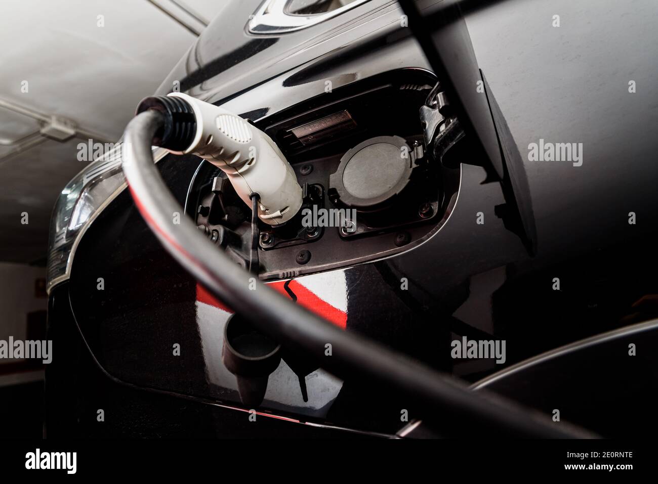 A car recharges its electric batteries inside a private garage with its ...