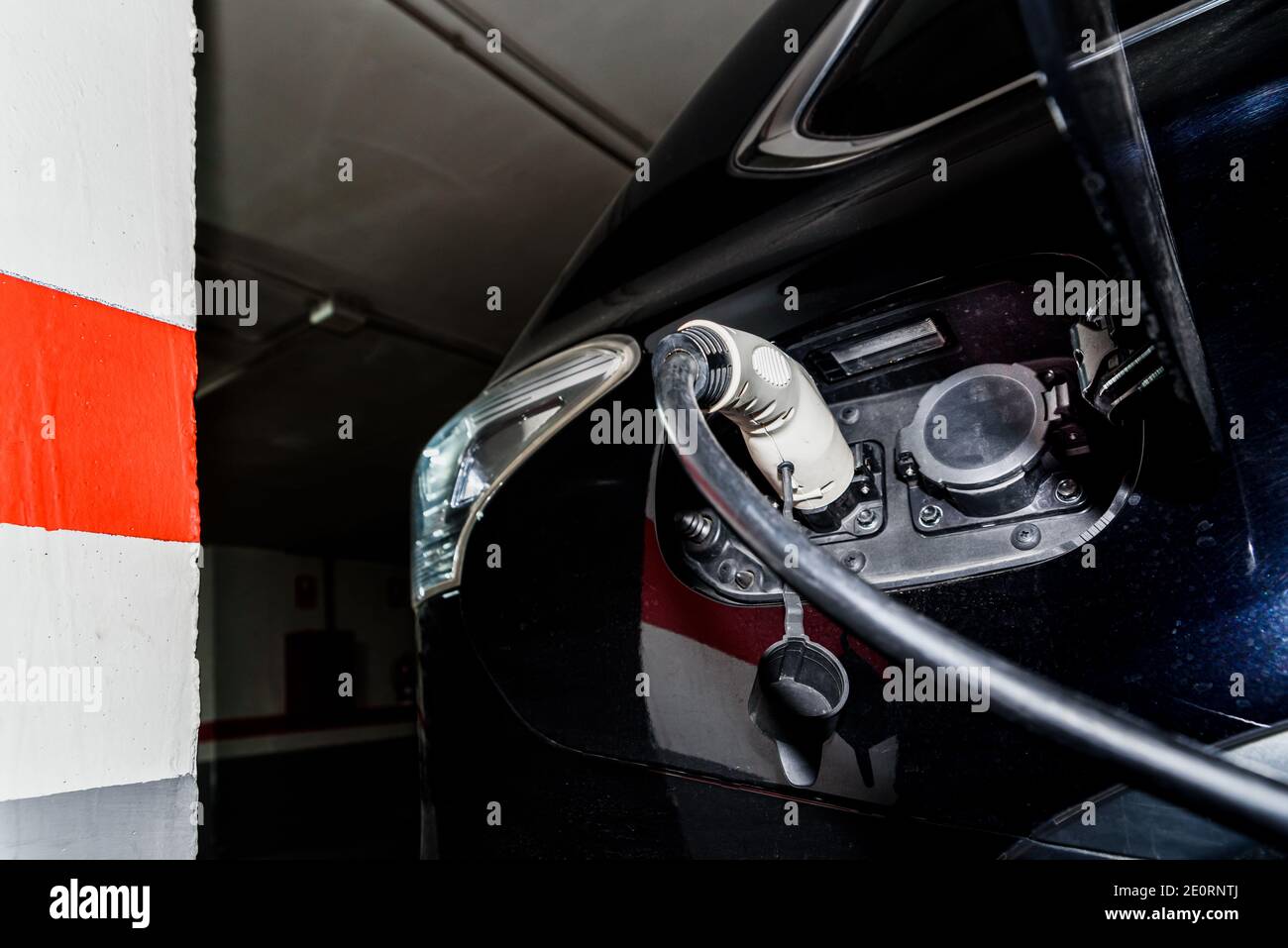 A car recharges its electric batteries inside a private garage with its ...