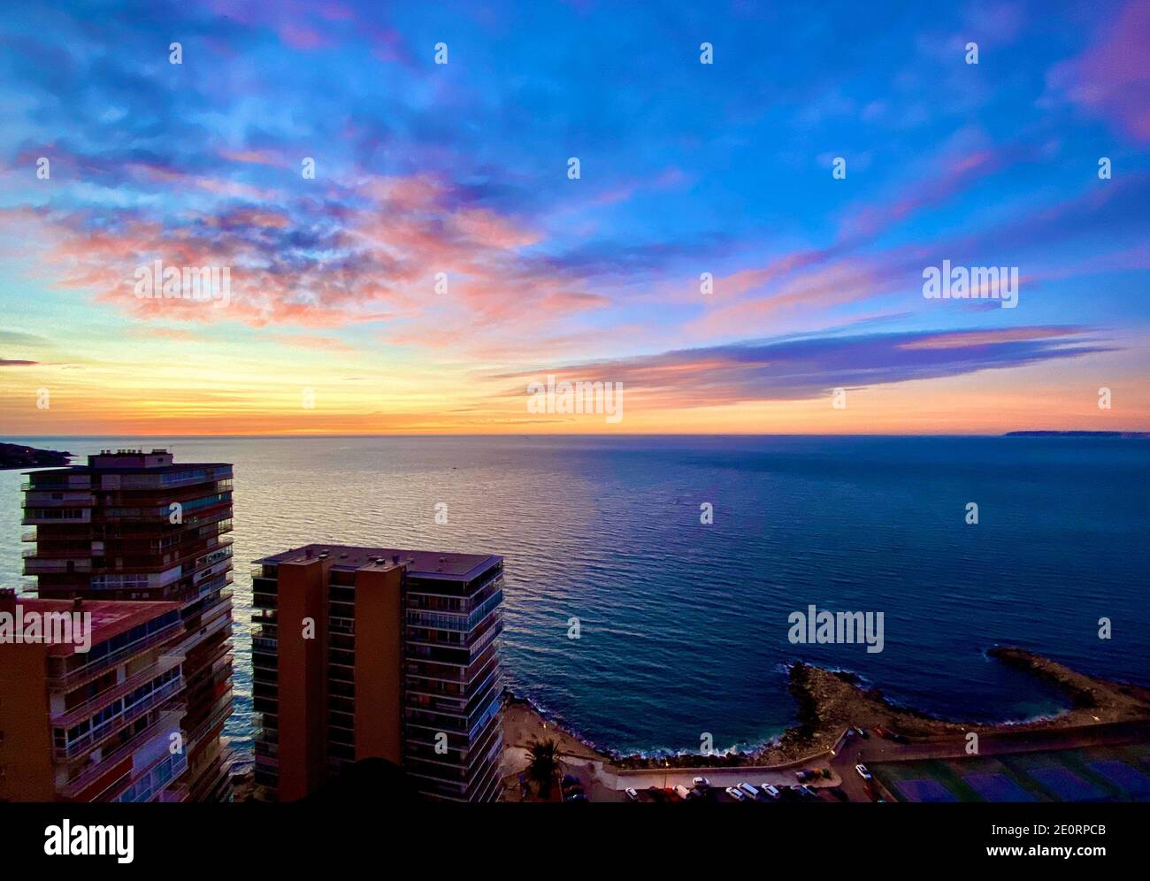beautiful and colorful sunrise in the beach with some clouds in spain ...