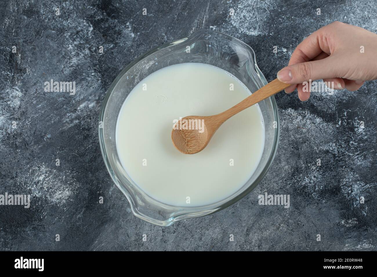 Female hand holding spoon from bowl of milk Stock Photo - Alamy