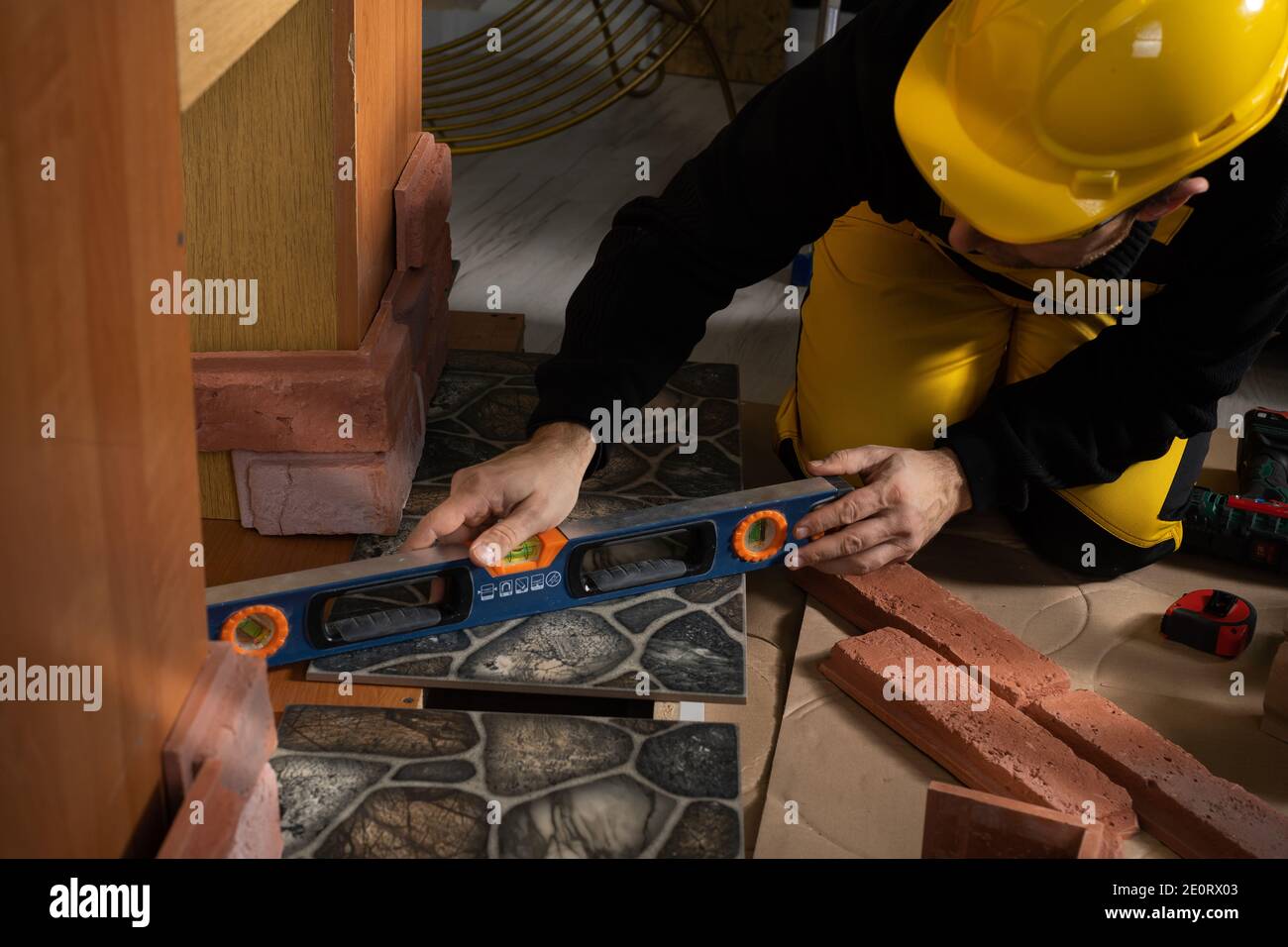While laying the terracotta, the general construction worker checks the correctness of execution ...