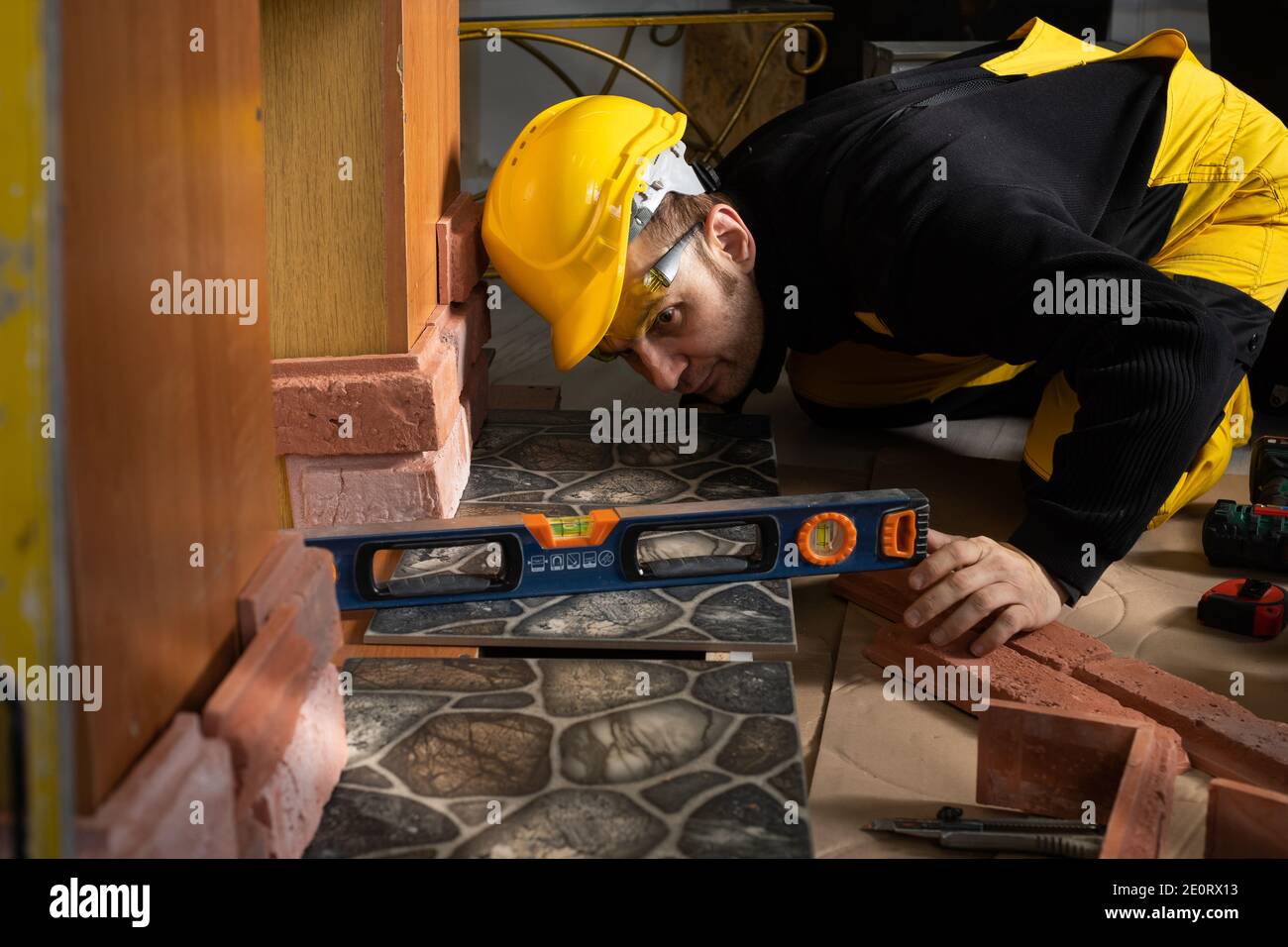 While laying the terracotta, the general construction worker checks the correctness of execution ...