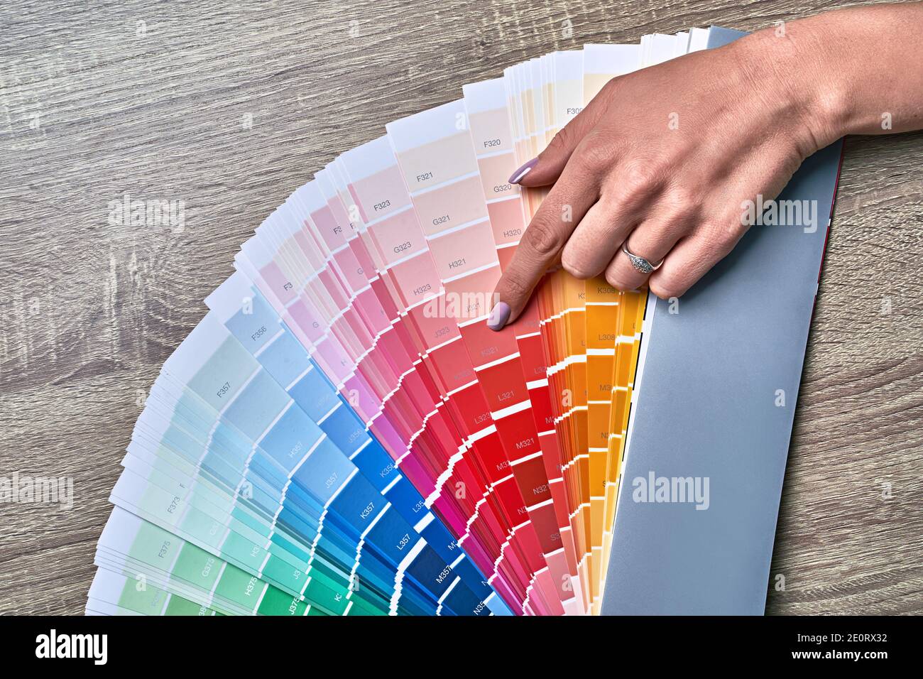 Color wheel for choosing paint tone. Hands of female interior designer ...