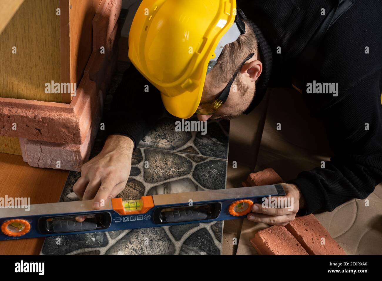 While laying the terracotta, the general construction worker checks the correctness of execution ...
