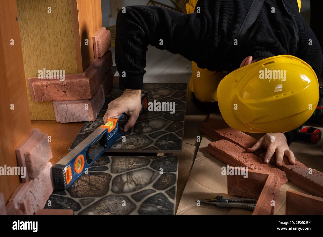 While laying the terracotta, the general construction worker checks the correctness of execution ...