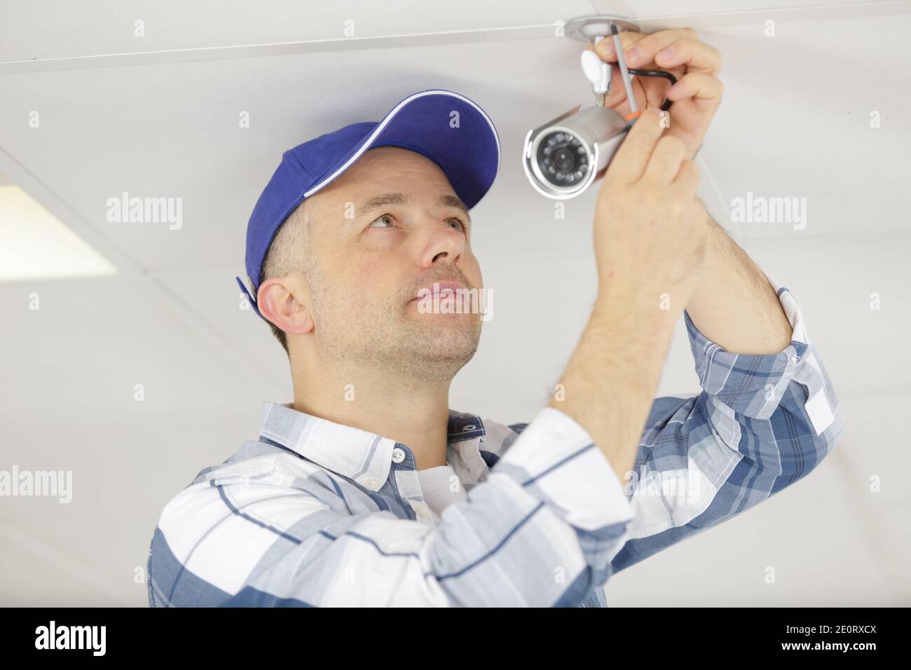 technician man setup cctv camera on wall Stock Photo - Alamy