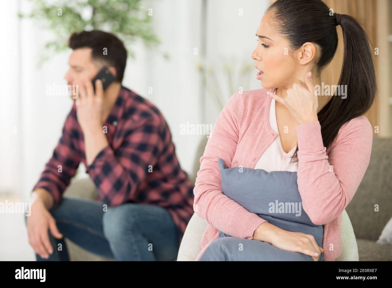 portrait of upset woman while man is using his phones Stock Photo - Alamy