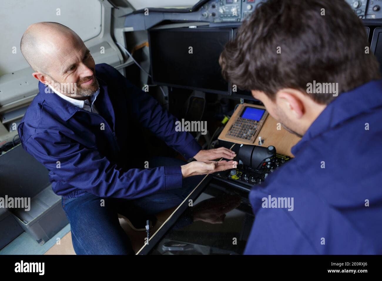 men working on remote control in cockpit factory Stock Photo - Alamy