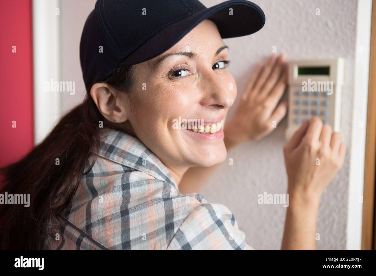 female cctv installer checking security alarm Stock Photo - Alamy