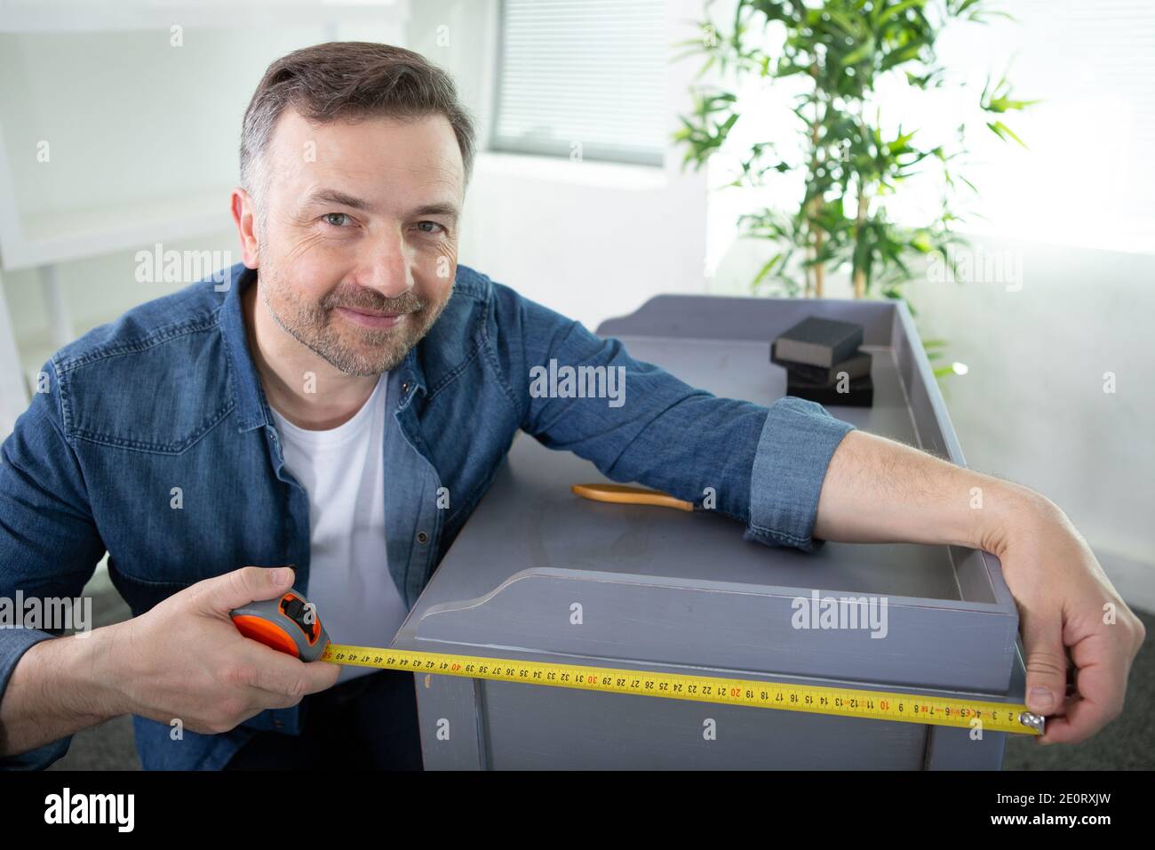 Handyman measuring furniture measuring tape hi-res stock photography ...