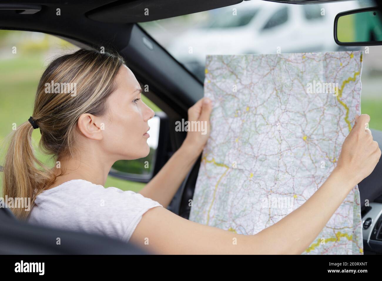 female driver looking at map Stock Photo - Alamy