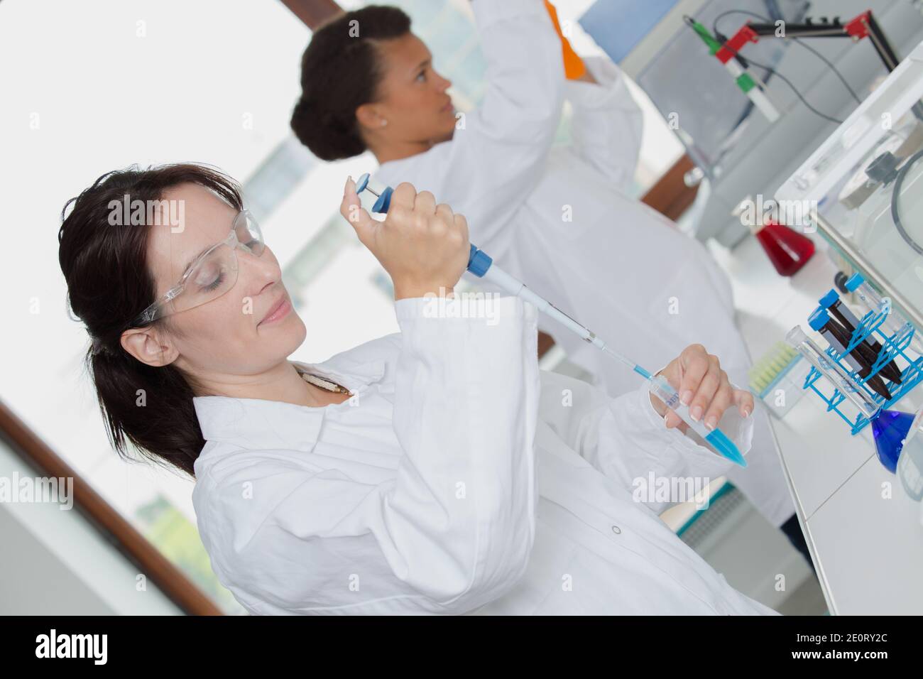 female scientist dripping liquid from pipette into test tube Stock ...