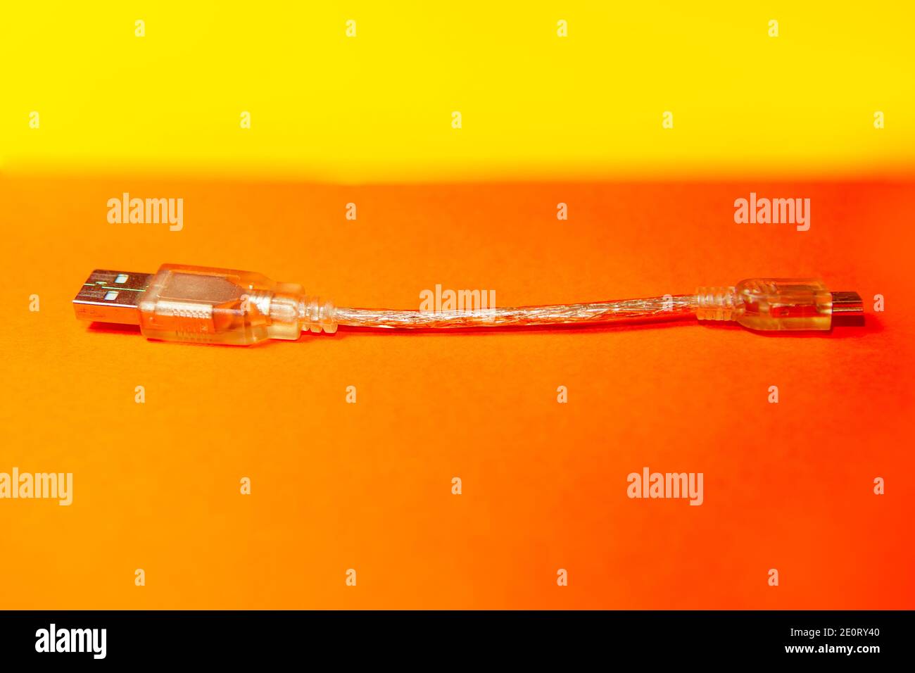 Transparent USB cable at yellow background Stock Photo - Alamy