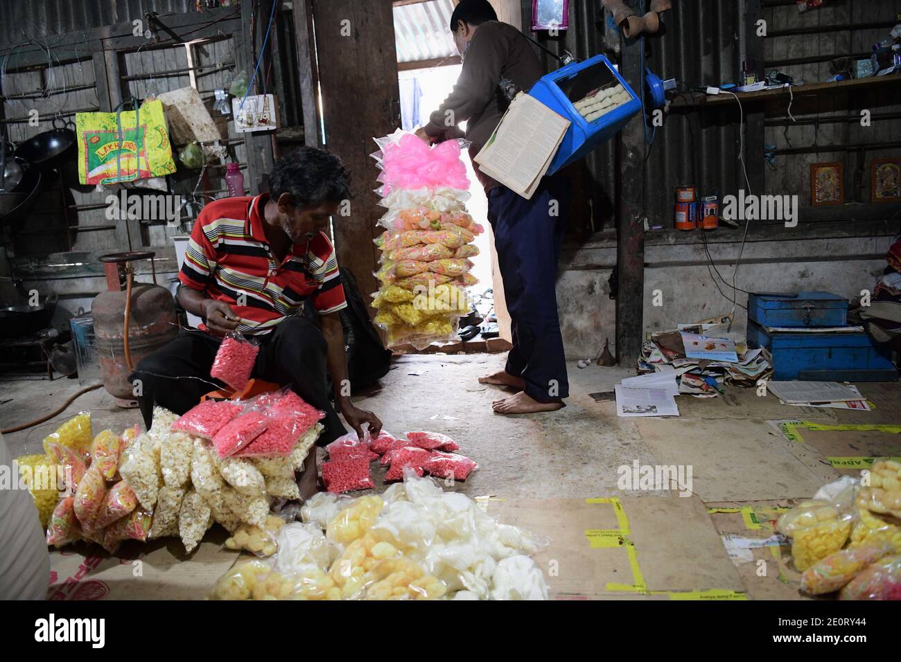 Workers making cotton candy at a factory. Cotton candy is a spun sugar ...