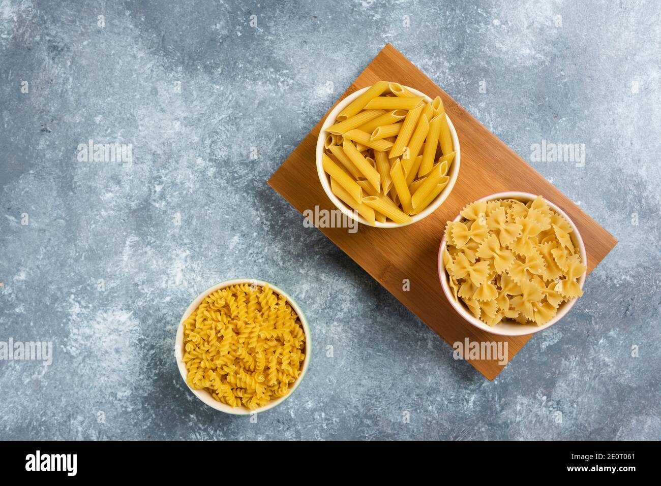 Different types of raw macaroni on a wooden board Stock Photo - Alamy