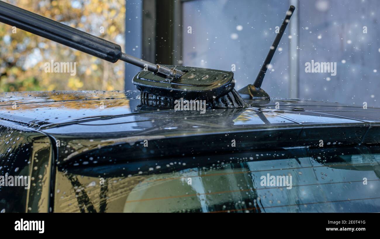 Car wash outdoor. Car roof washing with a brush Stock Photo - Alamy